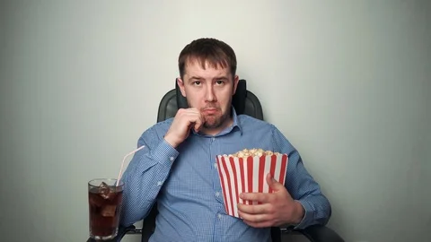 Sad man with popcorn watching movie | Stock Video | Pond5