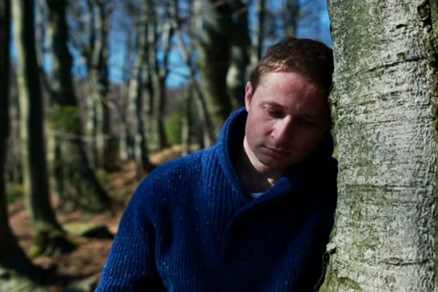 sad man sitting alone in the forest | Stock Video | Pond5