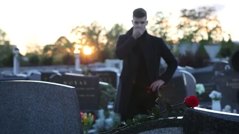 Sad man standing in front of a grave dur... | Stock Video | Pond5