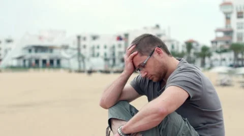 Sad pensive man sitting by the beach, ou... | Stock Video | Pond5