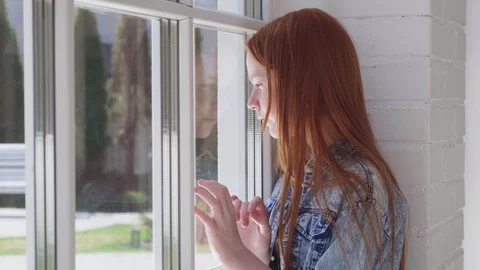 Sad teenager girl looking out window at ... | Stock Video | Pond5