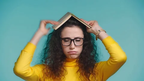 sad woman with book on head showing disl... | Stock Video | Pond5