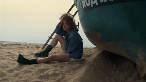 Sad woman sit beach near old boat cloudy... | Stock Video | Pond5