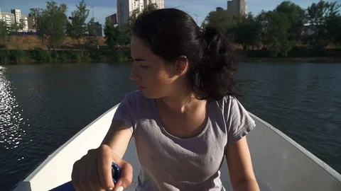 Sad young girl rowing in a boat | Stock Video | Pond5