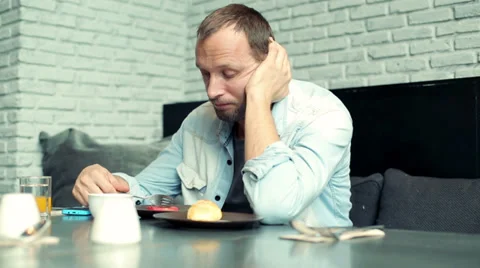 Sad young man eating fruit in cafe HD | Stock Video | Pond5