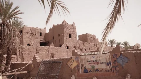 Sandstone village with palm trees in Sah... | Stock Video | Pond5