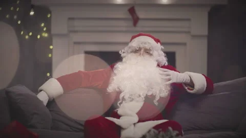 Santa Claus relaxing on couch and touchi... | Stock Video | Pond5
