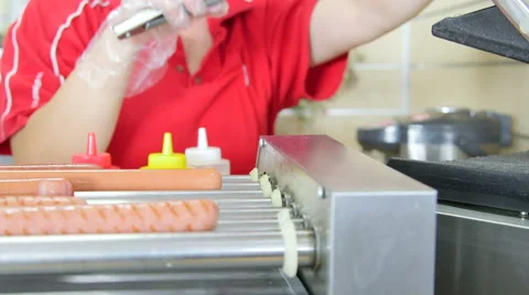 Sausages for hot dogs on rotating grills... | Stock Video | Pond5