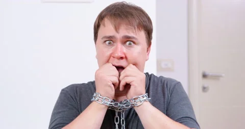 Scared man with wrists tied with chain s... | Stock Video | Pond5
