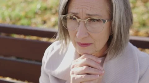 Scared woman in eyeglasses sitting bench... | Stock Video | Pond5