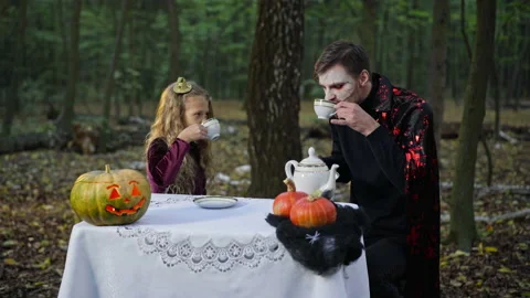 Scary vampire clinking tea cup with litt... | Stock Video | Pond5