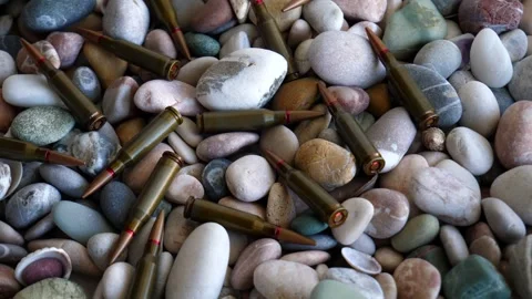 Scattered bullets on a pebbles and sea s... | Stock Video | Pond5