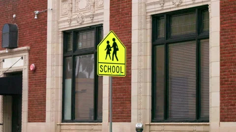 School Crossing Sign With Brick Building | Stock Video | Pond5