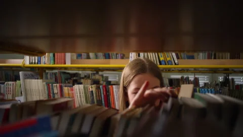 Schoolgirl searching and choosing books ... | Stock Video | Pond5