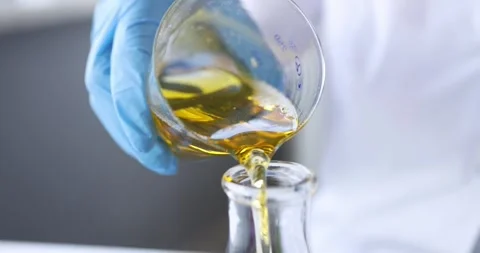 Scientist pouring oil into test tube clo... | Stock Video | Pond5