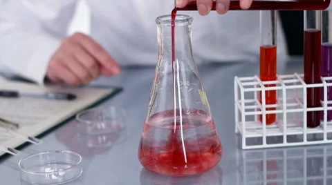 Scientist pouring red liquid into erlenm... | Stock Video | Pond5