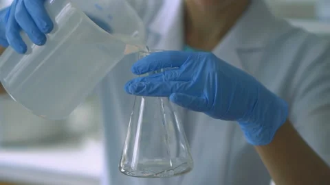 Scientist pouring red liquid in test tub... | Stock Video | Pond5
