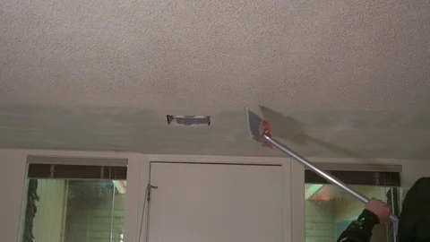 Scraping popcorn texture off a ceiling o... | Stock Video | Pond5