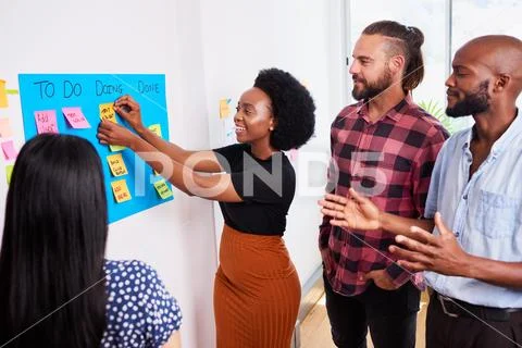 Scrum team participates in daily stand up on KANBAN board, mobile app ...