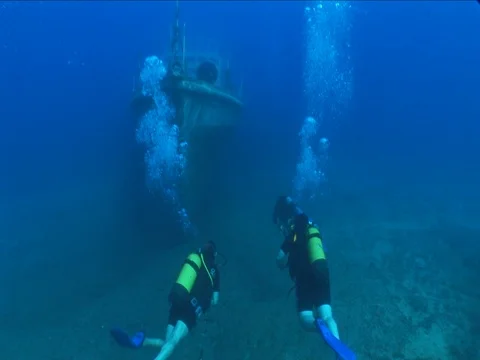 scuba divers exploring the ship wreck un... | Stock Video | Pond5