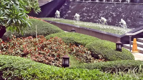Sculpture of bike riders in a pool besid... | Stock Video | Pond5