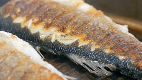 Sea bass fish on hot grill close up 4K | Stock Video | Pond5