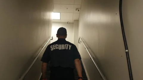 Security guard patrolling on stairs insi... | Stock Video | Pond5