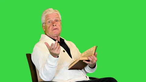 Senior man reading aloud a book on camer... | Stock Video | Pond5