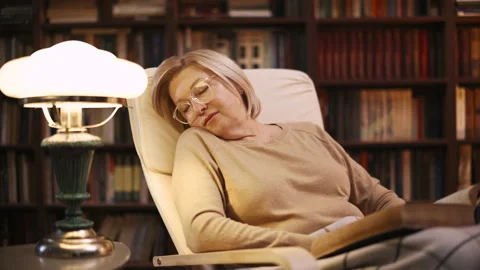 Senior woman falling asleep while readin... | Stock Video | Pond5