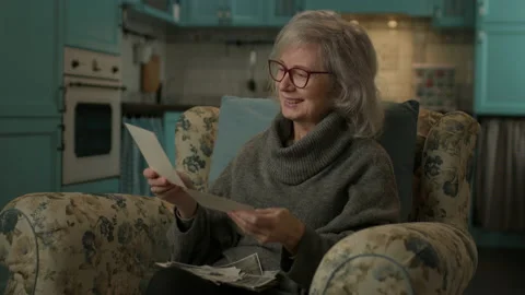 Senior Woman Looking At Old Photos. Elde... | Stock Video | Pond5