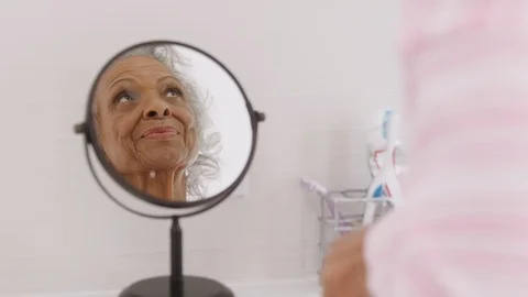 Senior Woman Looking At Reflection In Ba... | Stock Video | Pond5