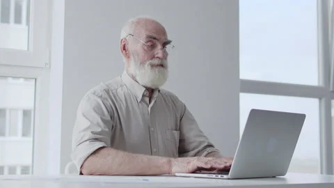 Serious old man typing on laptop sitting... | Stock Video | Pond5