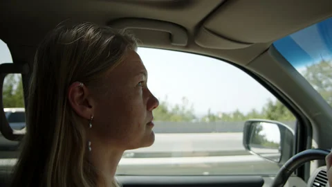 serious young woman driving car along hi... | Stock Video | Pond5