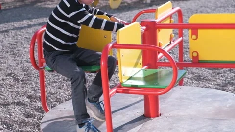 Seven-year-old boy spinning on the carou... | Stock Video | Pond5