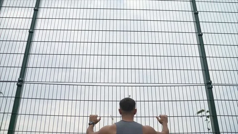 Sexy man standing behind metal gates. Wi... | Stock Video | Pond5