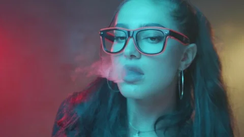 Sexy woman smoking in neon color light | Stock Video | Pond5