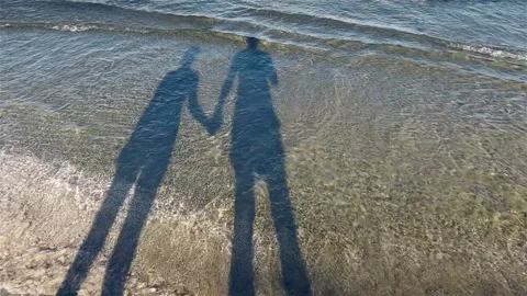 Shadow couple on the beach holding hands... | Stock Video | Pond5