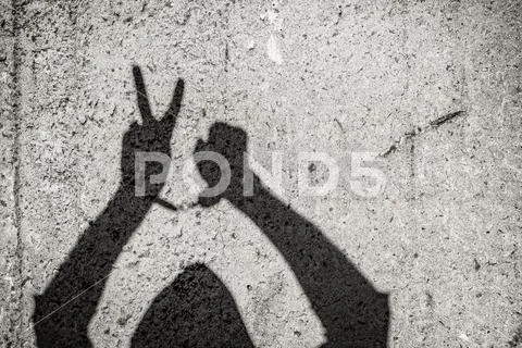 The shadow of a criminal in handcuffs on the prison wall. Law. Prison ...