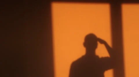 Shadow of man standing on window watchin... | Stock Video | Pond5