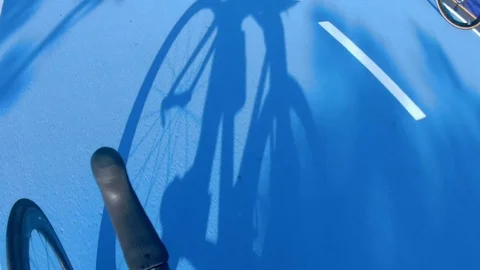 shadow of road bike on blue lane moving ... | Stock Video | Pond5