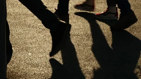 Shadows of walking peoples legs at sunse... | Stock Video | Pond5