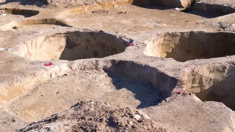 Shallow, round pits dug into earth marke... | Stock Video | Pond5