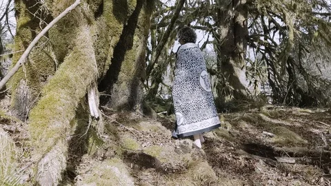 Shaman woman kneeling at the base of a m... | Stock Video | Pond5