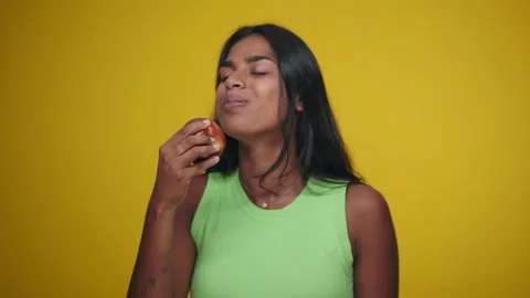 She eating apple with smiling at yellow ... | Stock Video | Pond5