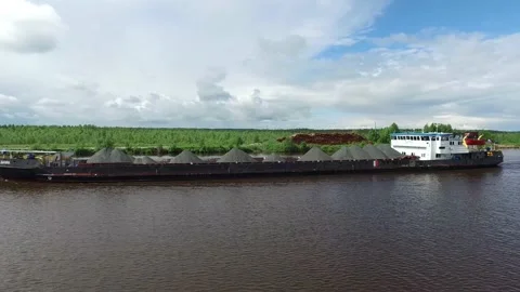 a ship with piles of stones floats on th... | Stock Video | Pond5