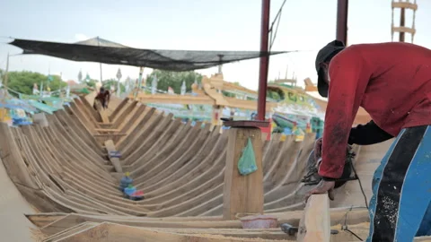 A shipbuilder cuts the timber of a tradi... | Stock Video | Pond5