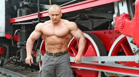 shirtless bodybuilder stands on railroad... | Stock Video | Pond5