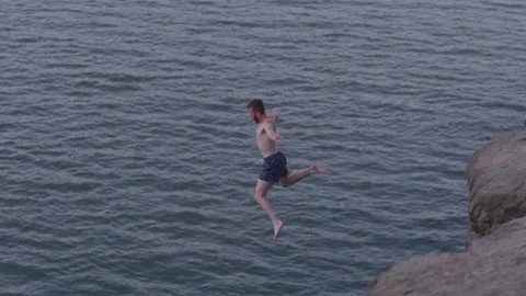 Shirtless Guy Jumps From Cliff Into Lake | Stock Video | Pond5