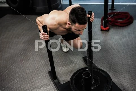 Shirtless man pushing heavy weights ~ Premium Photo #60378434