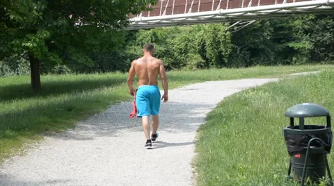 Shirtless muscle man jogging on pathway | Stock Video | Pond5